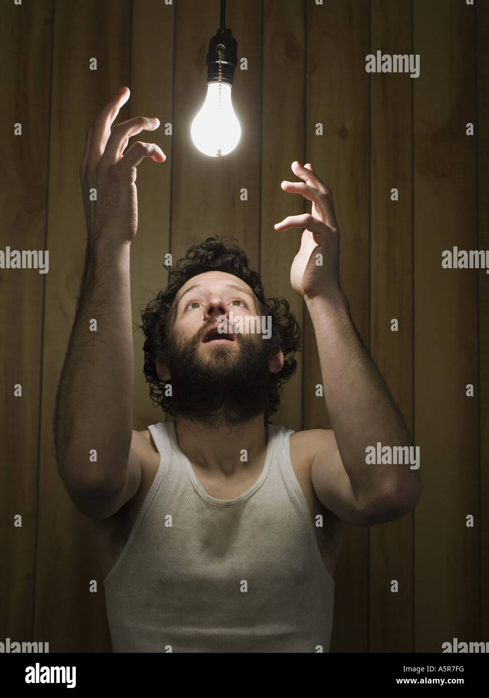 Man reaching up to light bulb Stock Photo - Alamy