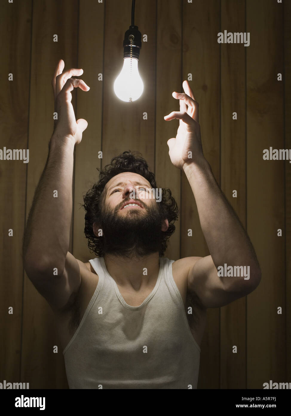 Man reaching up to light bulb Stock Photo - Alamy