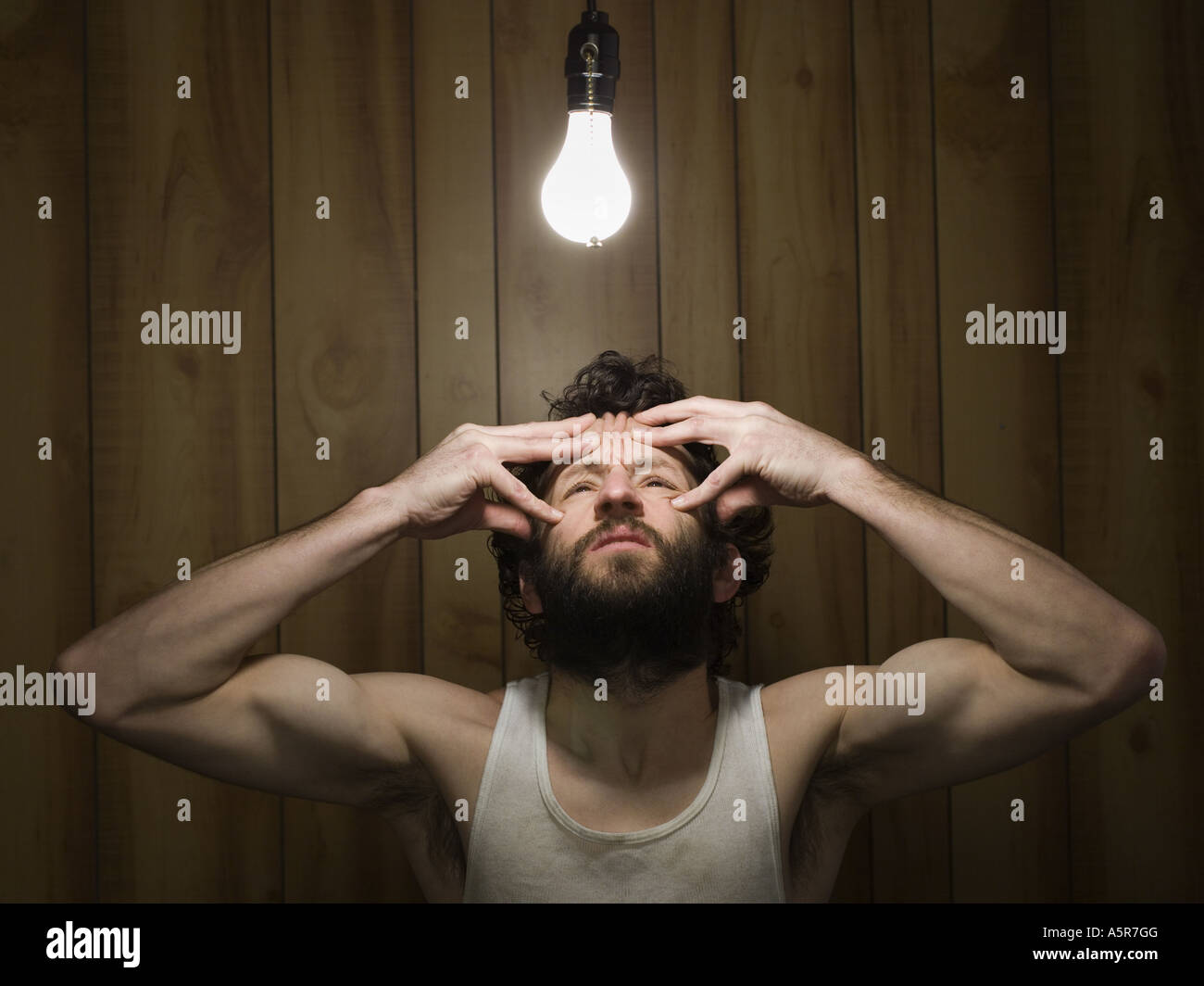 Man reaching to light bulb gritting teeth Stock Photo - Alamy