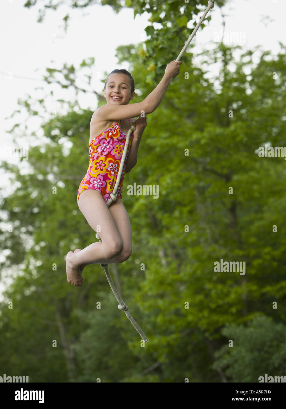 Portrait of a girl swinging on a rope Stock Photo - Alamy