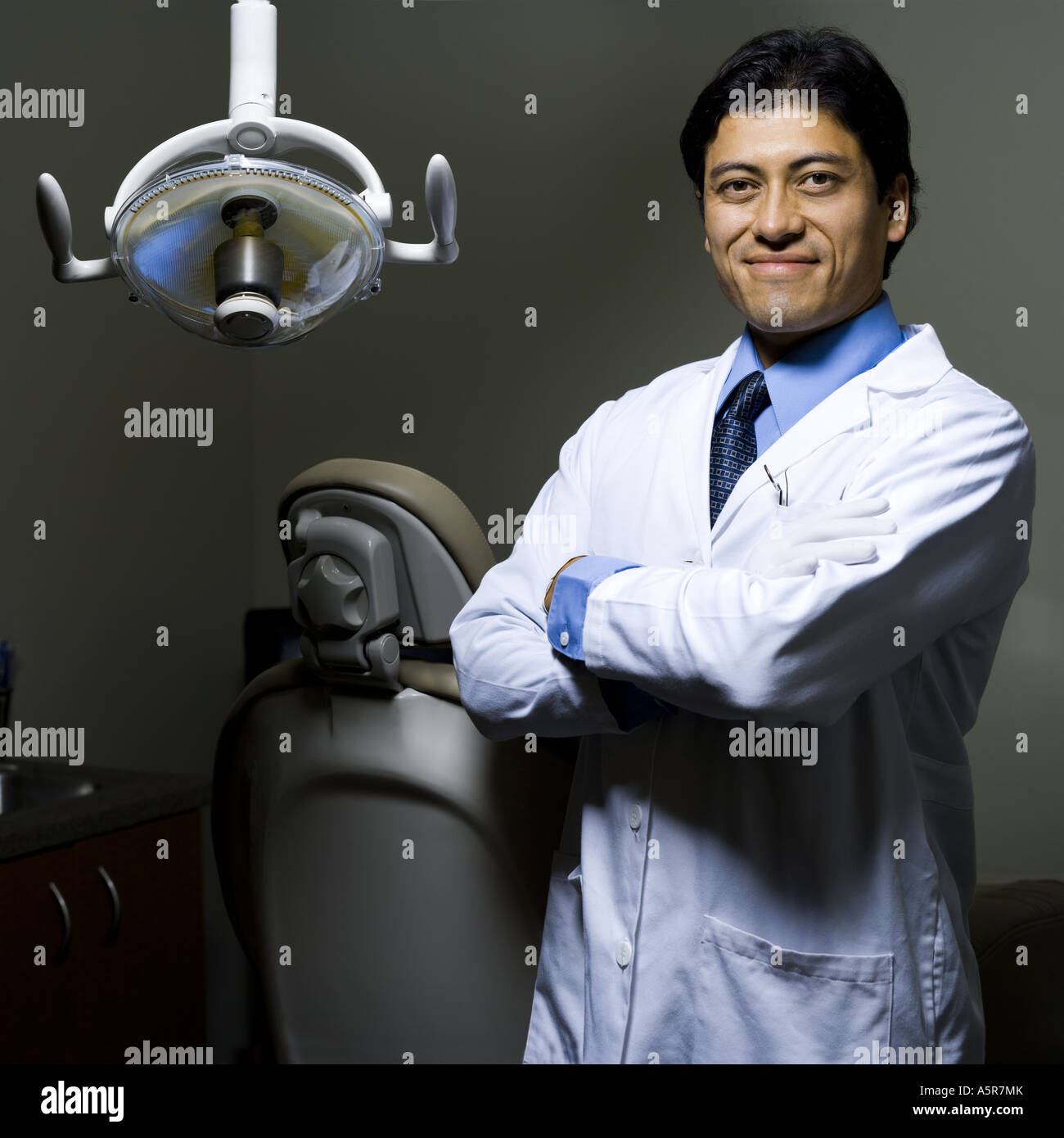 Dentist with arms crossed smiling Stock Photo - Alamy