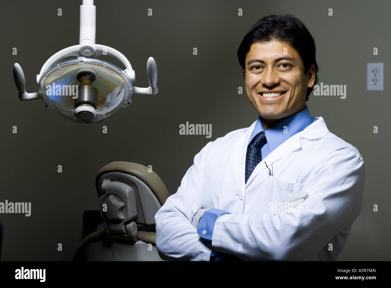 Dentist with arms crossed smiling Stock Photo - Alamy