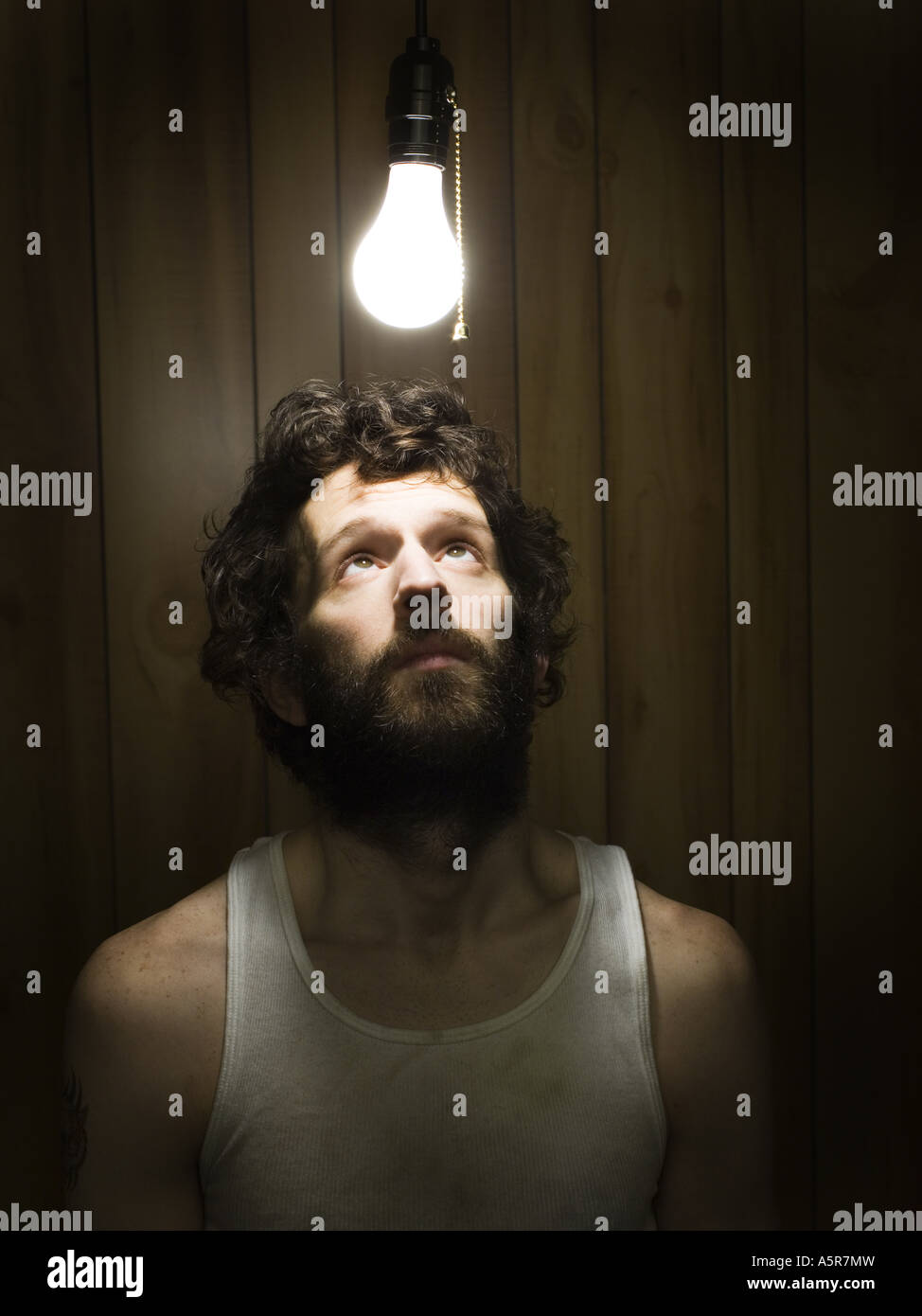 Man looking up at light bulb Stock Photo - Alamy