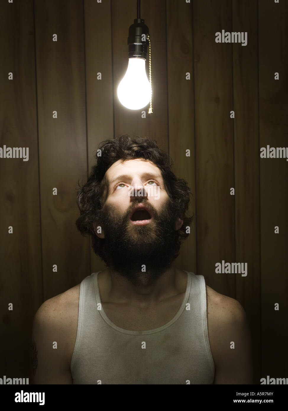 Man looking up at light bulb Stock Photo - Alamy