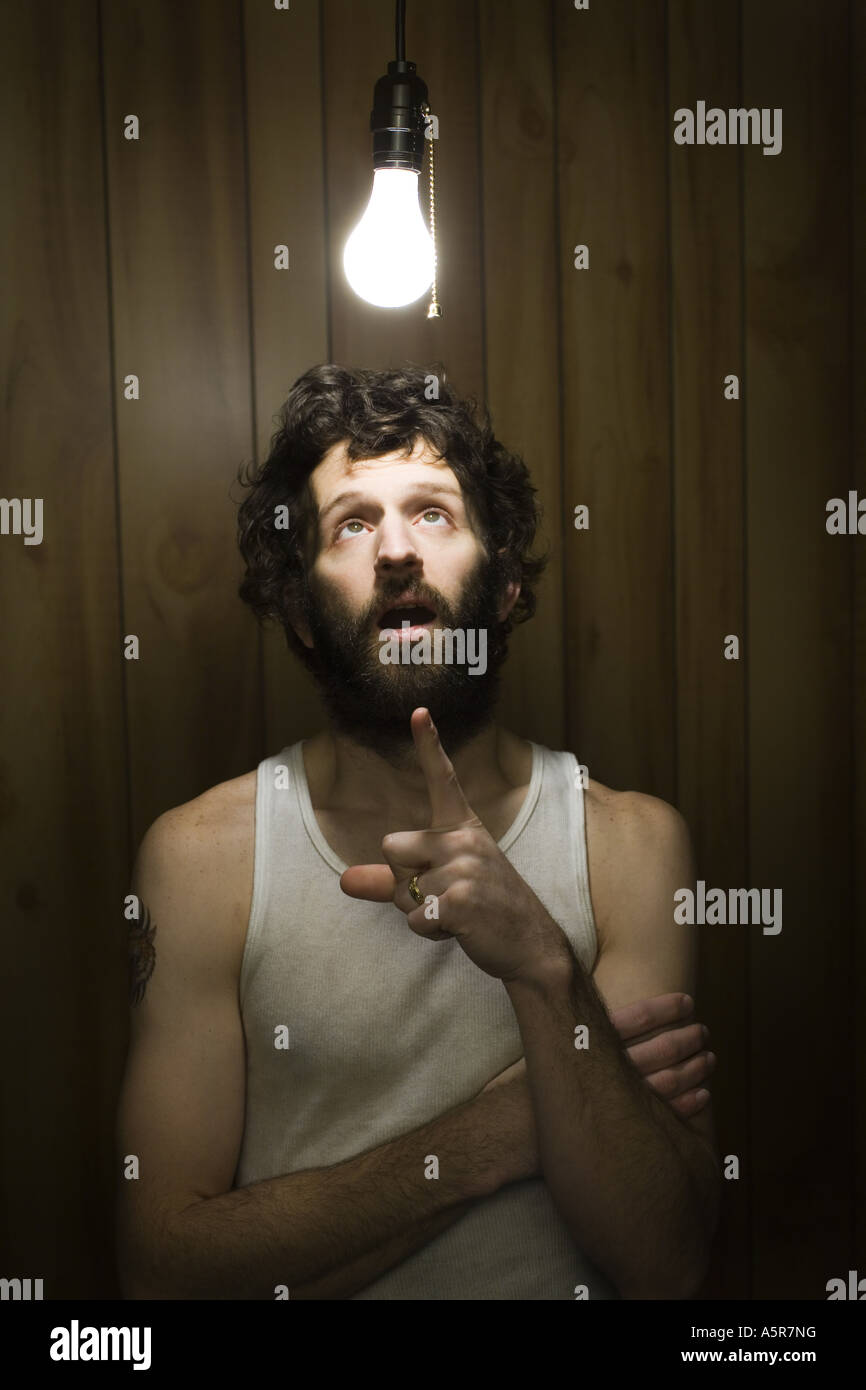 Man looking up at light bulb Stock Photo - Alamy