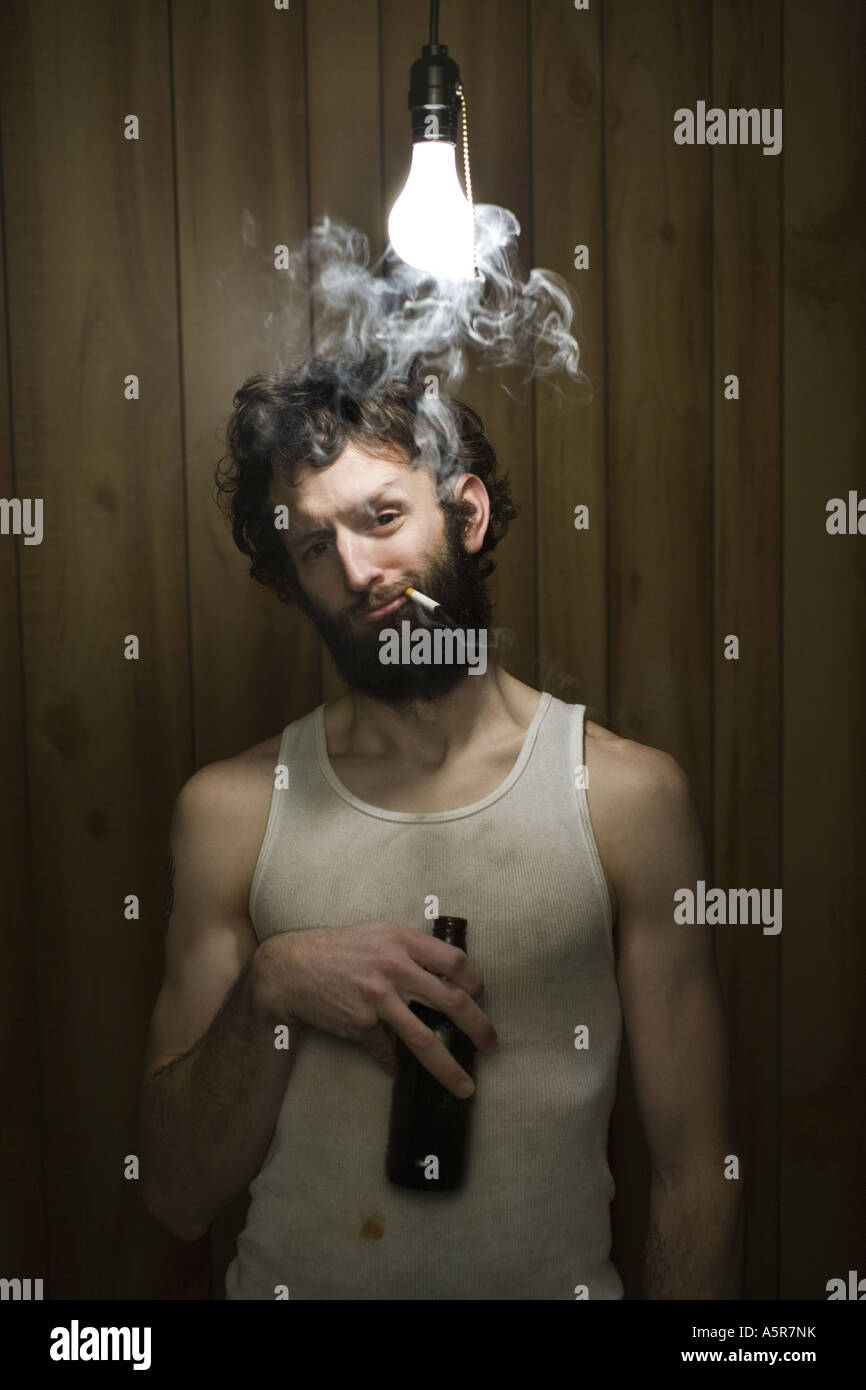 Man standing under light bulb with cigarette and beer bottle Stock ...