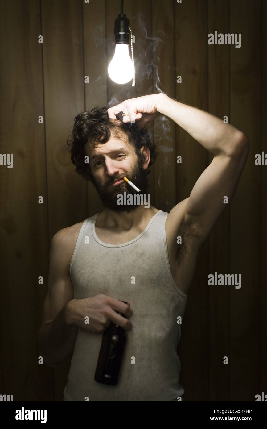 Man standing under light bulb with cigarette and beer bottle Stock ...