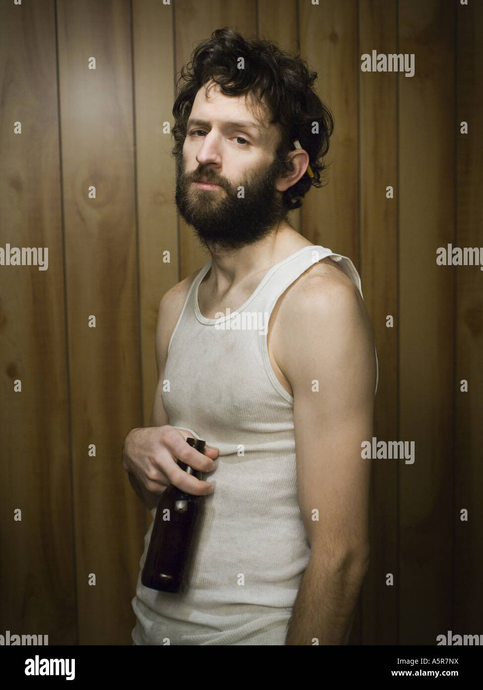Man standing with crossed arms and beer bottle Stock Photo - Alamy
