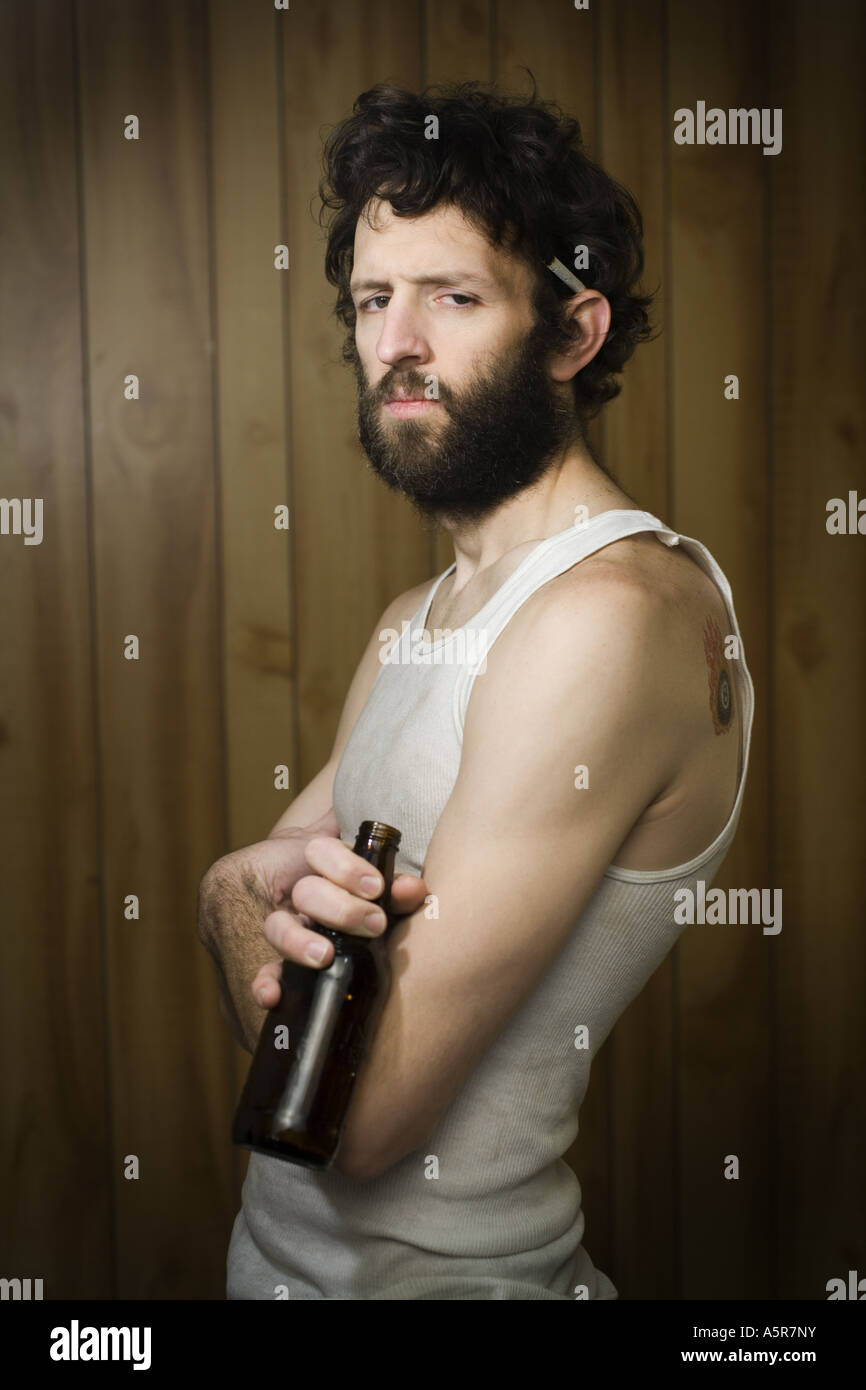 Man standing with crossed arms and beer bottle Stock Photo - Alamy