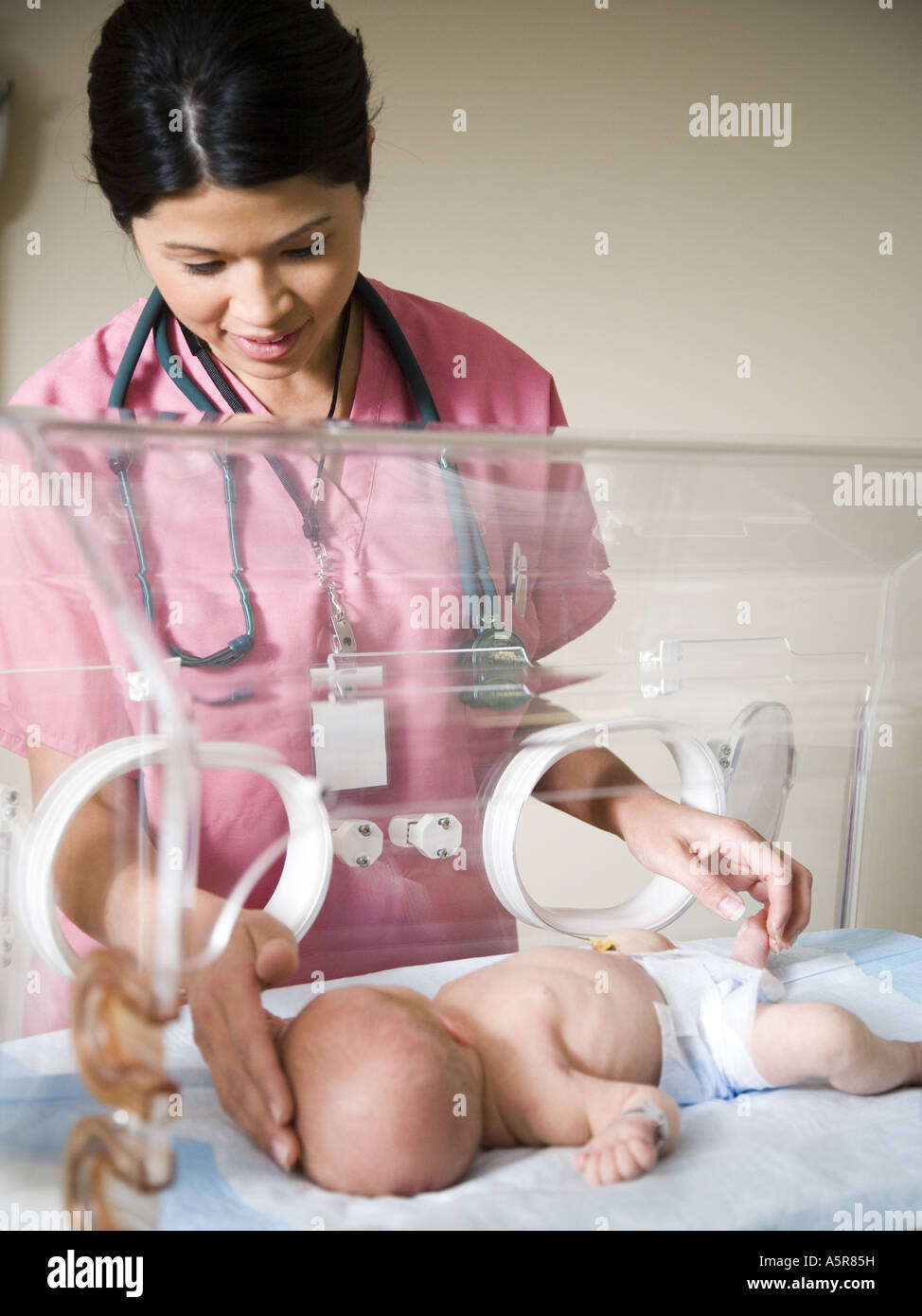 Baby in incubator with female nurse Stock Photo - Alamy