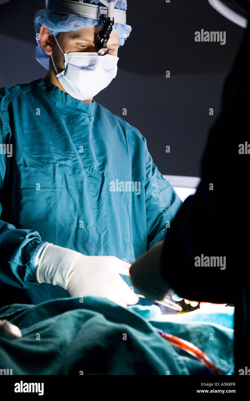 Female doctor in scrubs with head light in surgery Stock Photo - Alamy