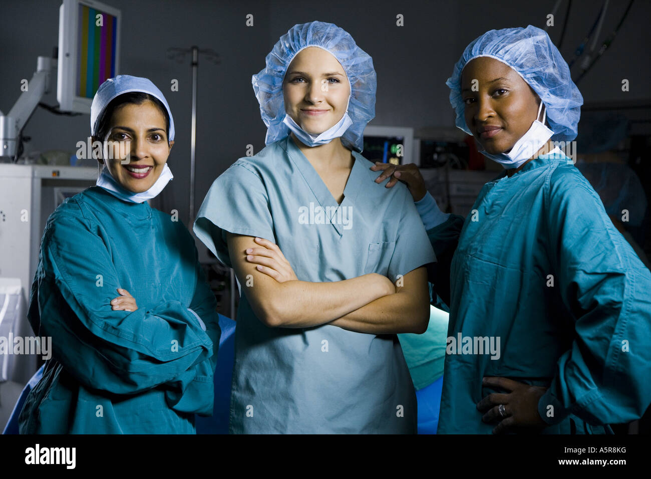 Three women in scrubs with arms crossed smiling Stock Photo - Alamy
