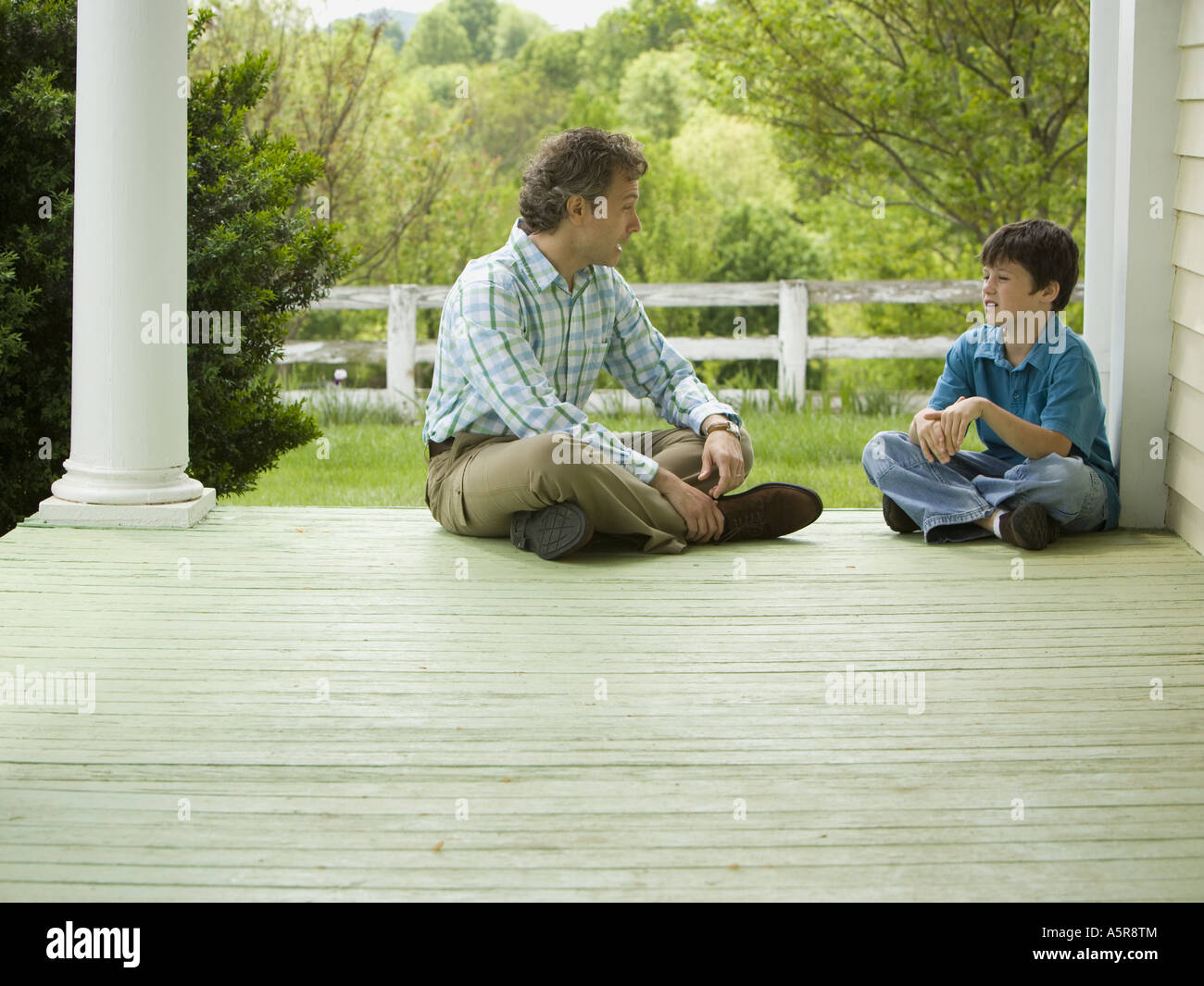 Profile of a man and his son sitting on a wooden floor Stock Photo - Alamy