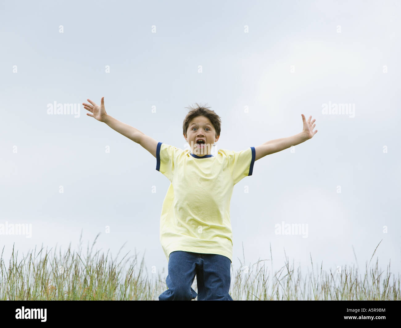 Portrait of a boy running with his arms outstretched Stock Photo - Alamy