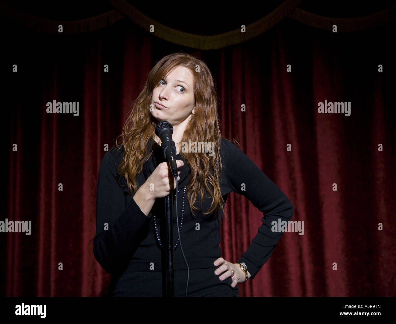 Man in suit with microphone making funny faces Stock Photo - Alamy