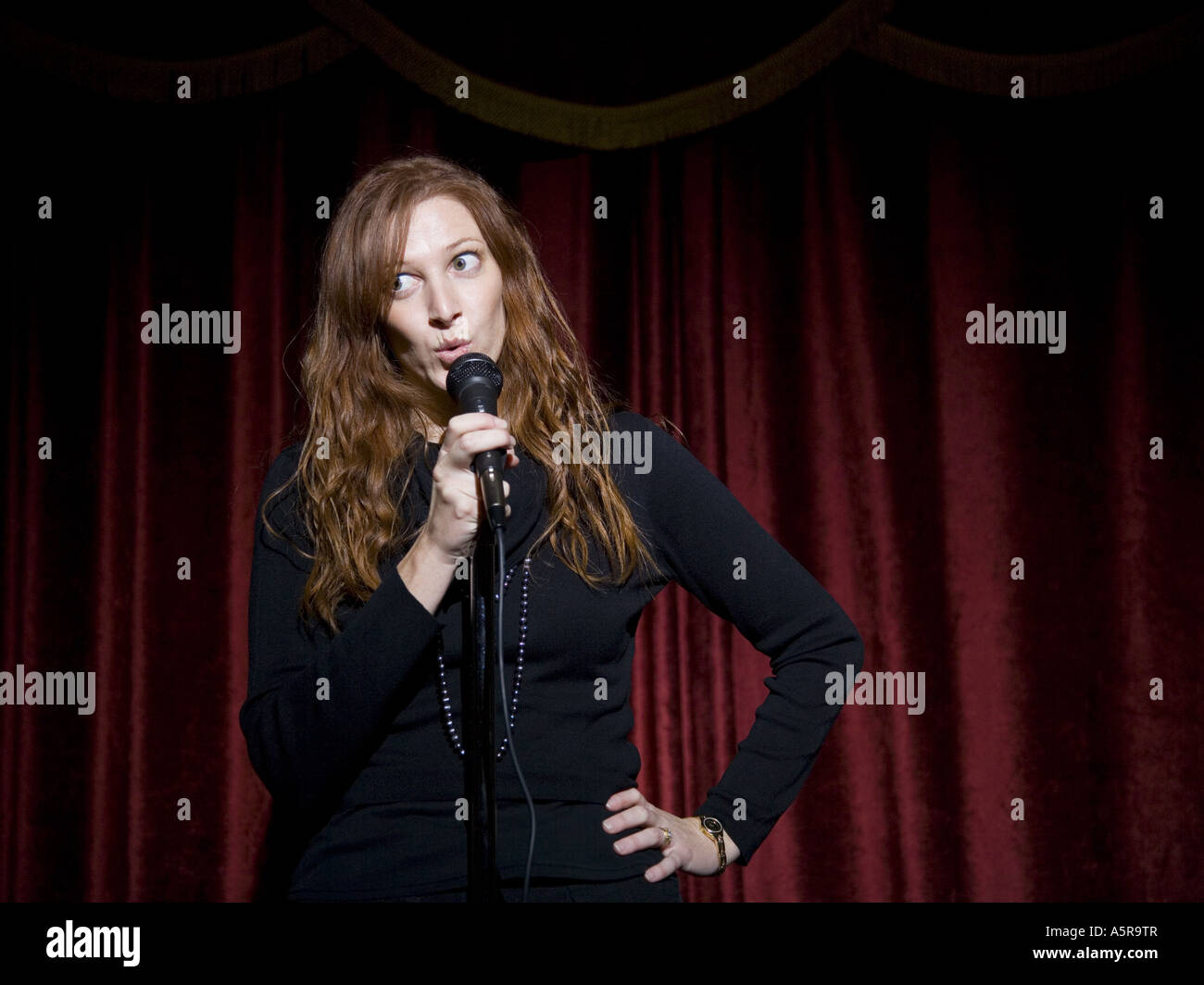 Man in suit with microphone making funny faces Stock Photo - Alamy