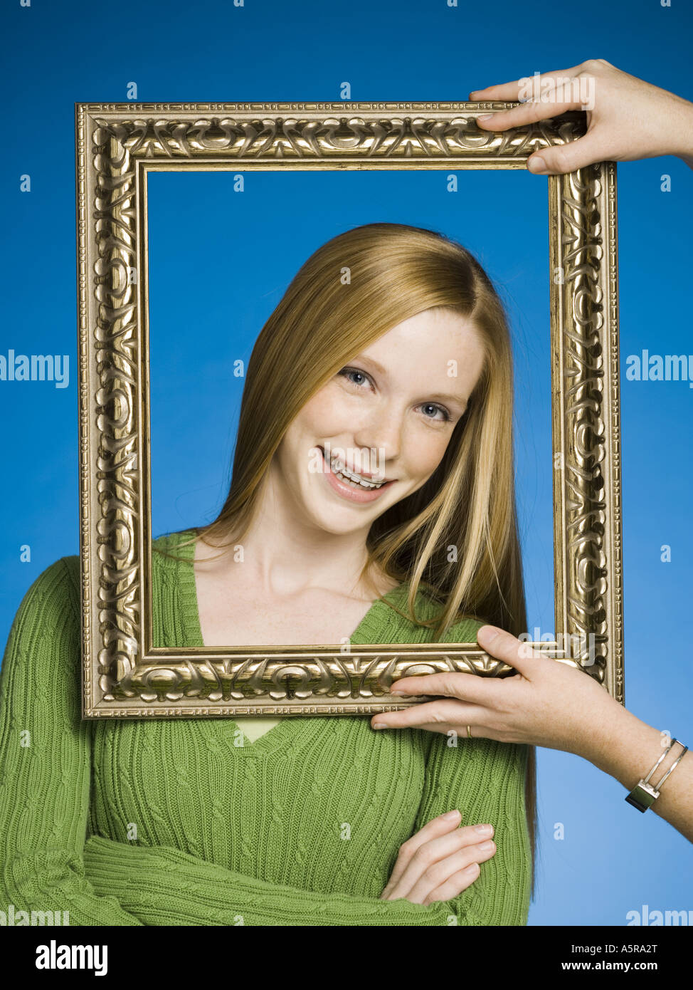 Girl looking through picture frame smiling Stock Photo - Alamy