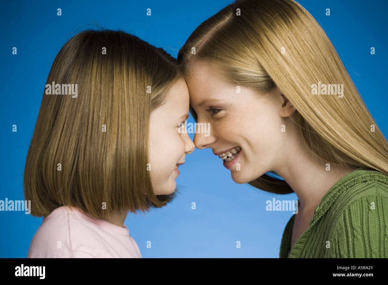 Two girls face to face smiling Stock Photo - Alamy