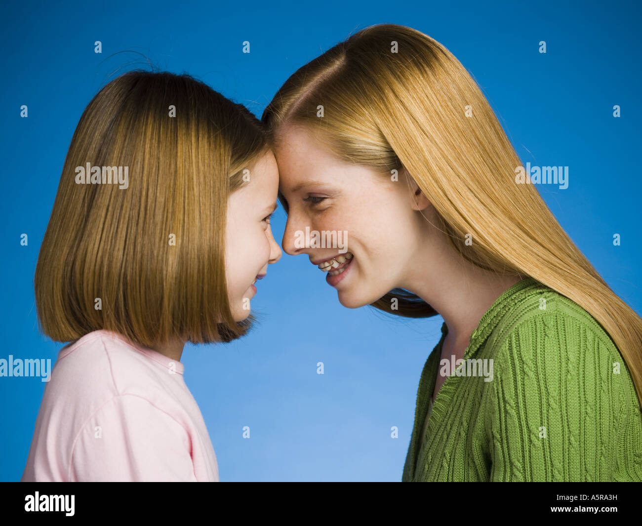 Two girls face to face smiling Stock Photo - Alamy