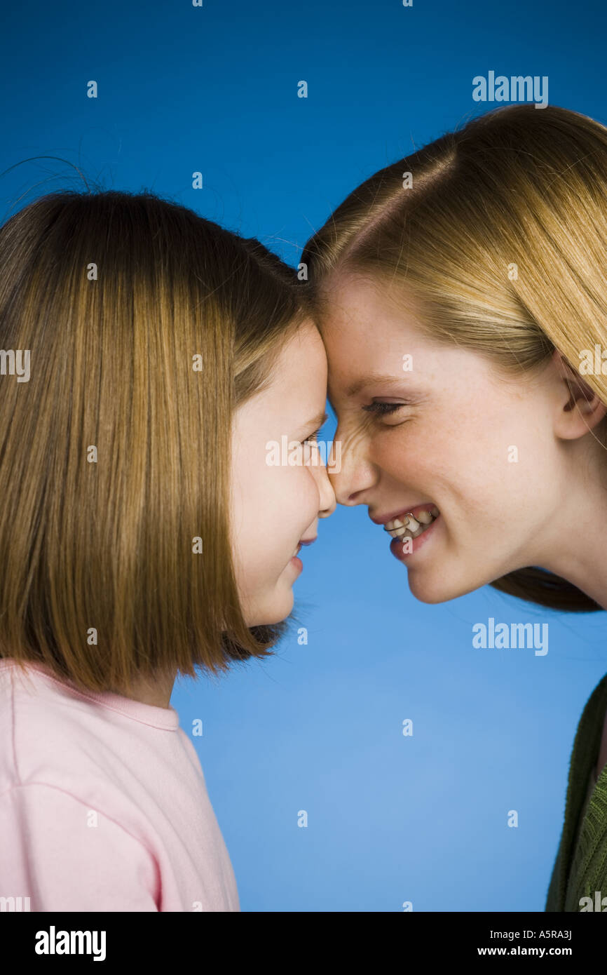 Two girls face to face smiling Stock Photo - Alamy