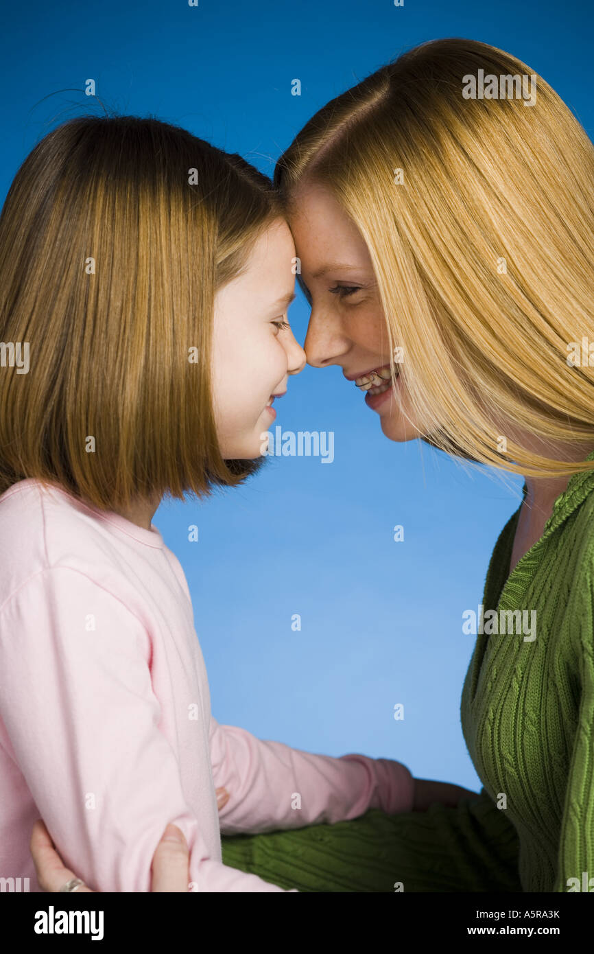 Two girls face to face smiling Stock Photo - Alamy