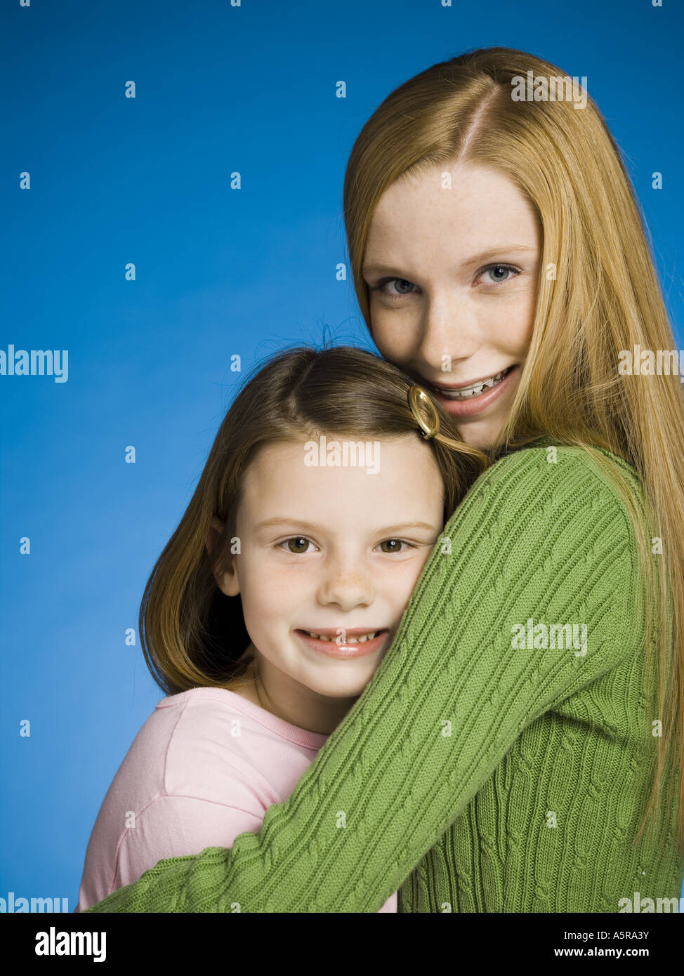 Teenage girl and young girl hugging Stock Photo - Alamy