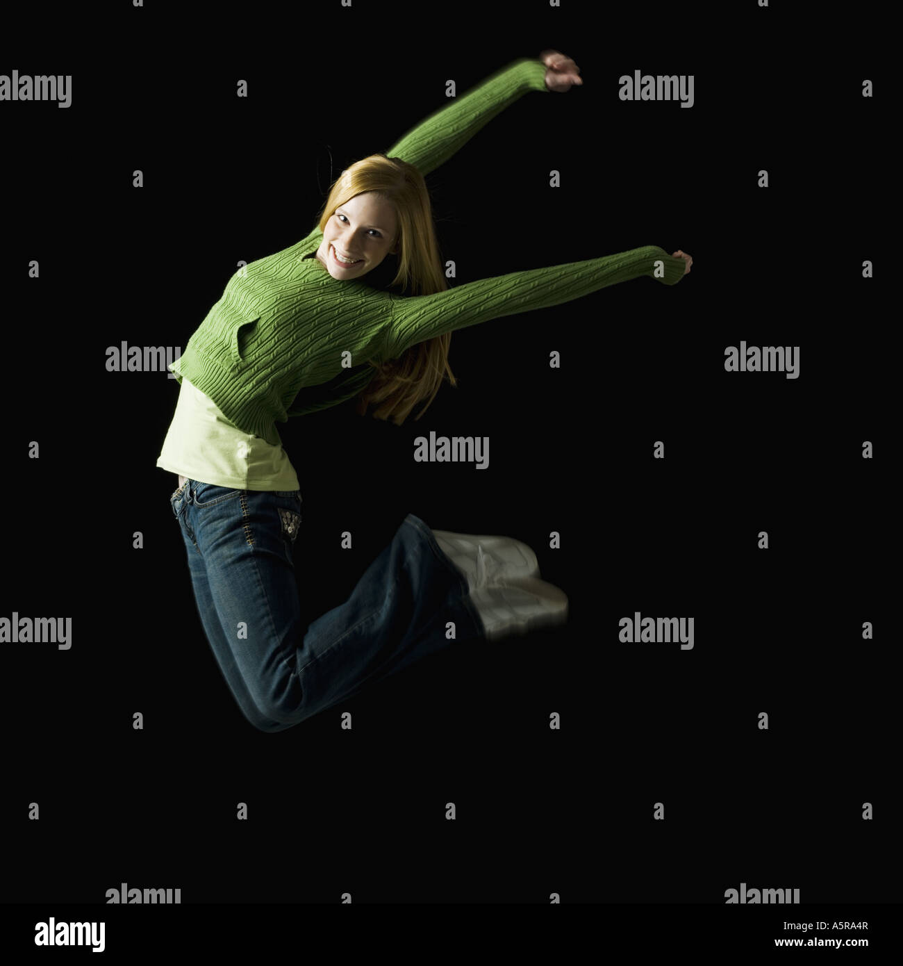Girl leaping and smiling Stock Photo - Alamy