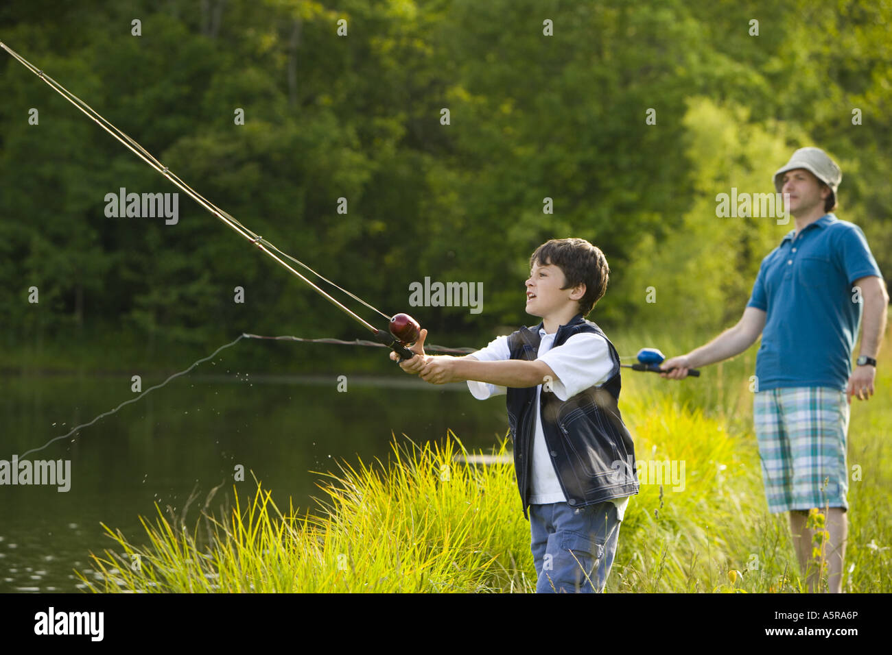 Profile of a man and his son fishing Stock Photo - Alamy