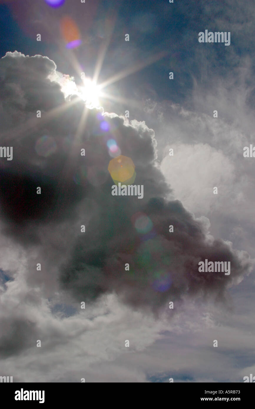 Moody sky with sun emerging from behind dark cloud Stock Photo - Alamy