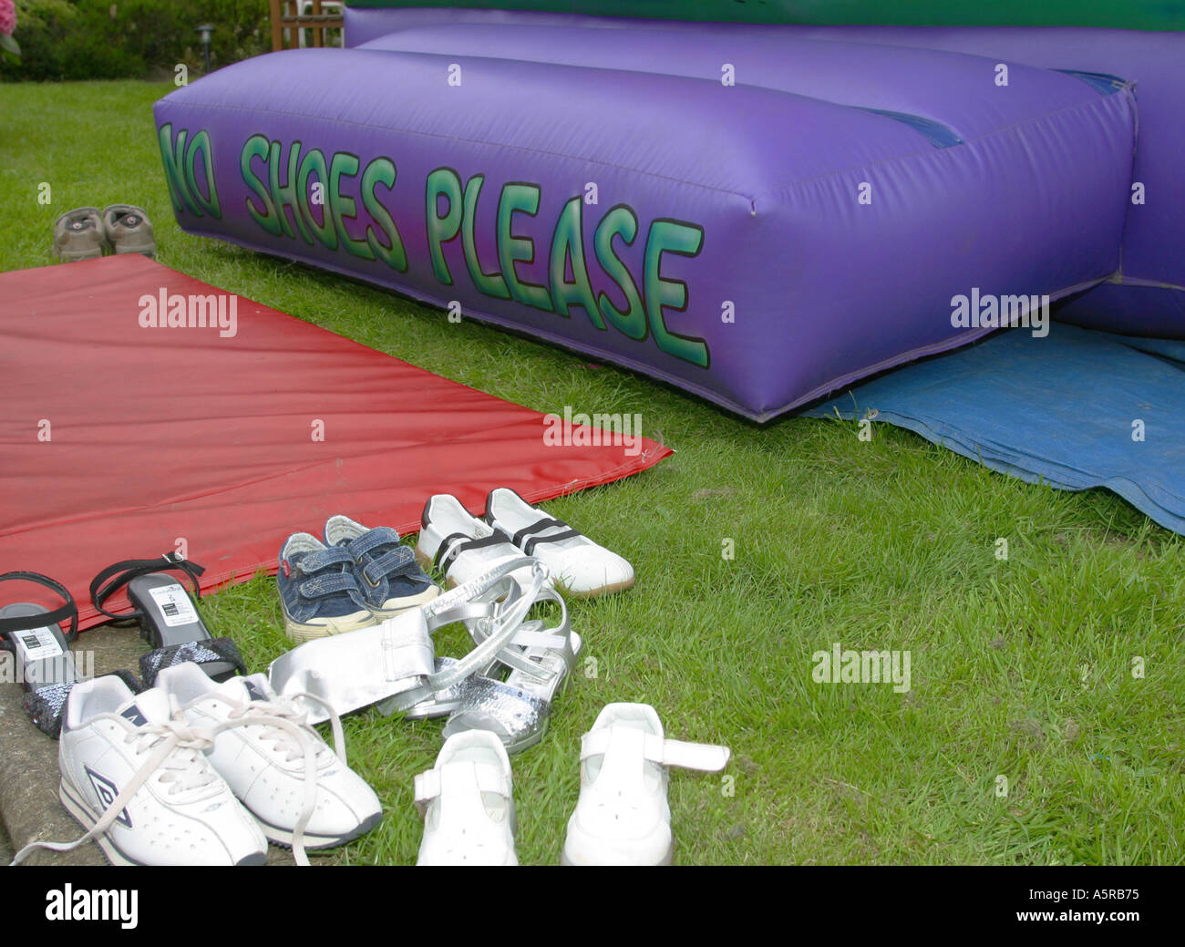 Discarded childrens shoes beside inflatable bouncy castle Stock Photo ...