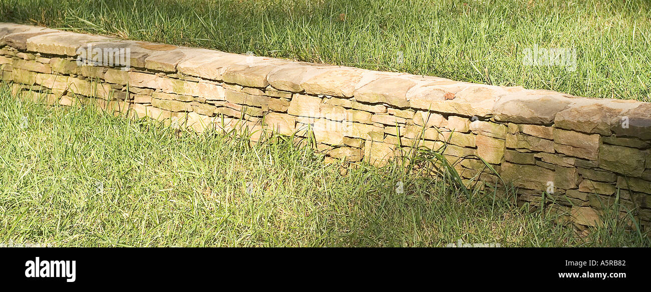 Stone rock wall landscaping fence Stock Photo - Alamy
