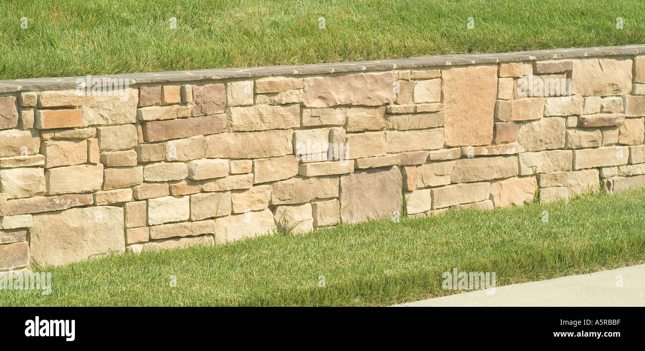 Stone rock wall landscaping fence Stock Photo - Alamy