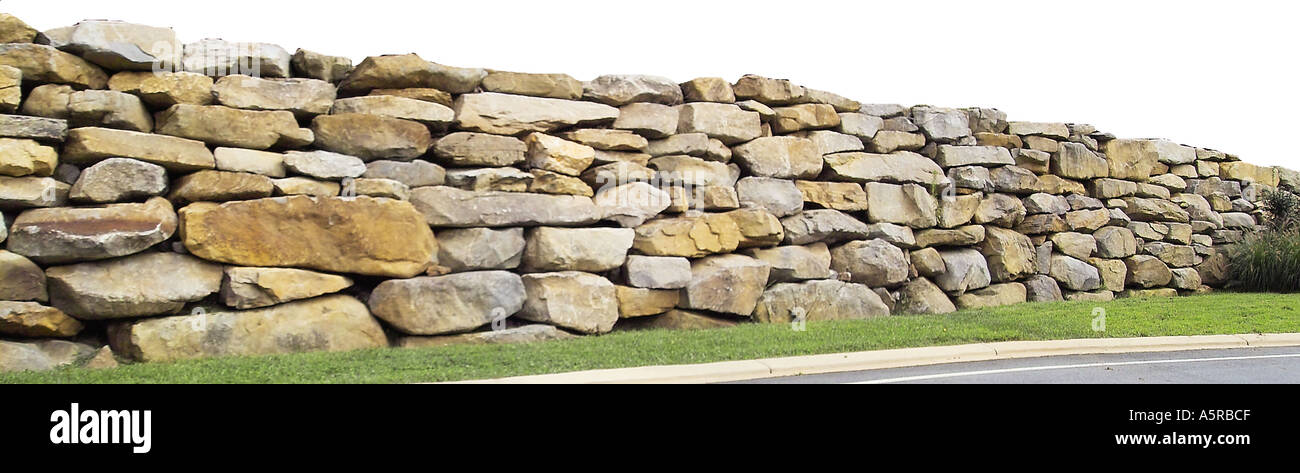 Stone rock wall landscaping fence Stock Photo - Alamy