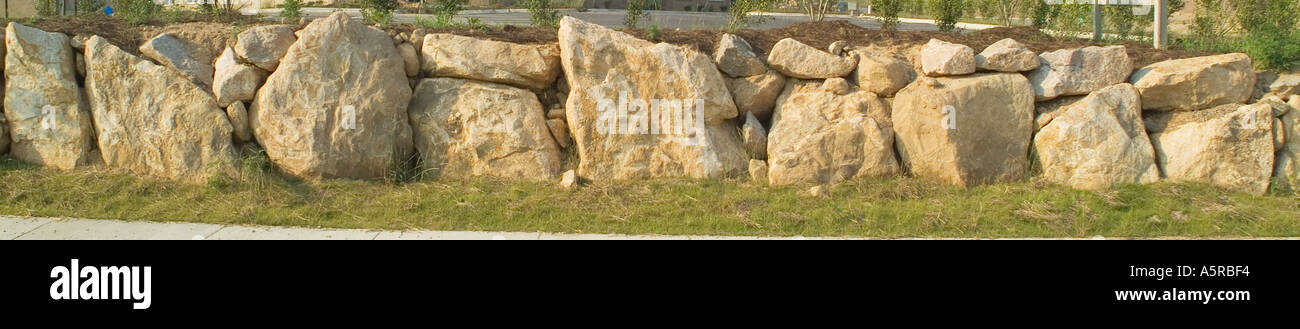 Stone rock wall landscaping fence Stock Photo - Alamy