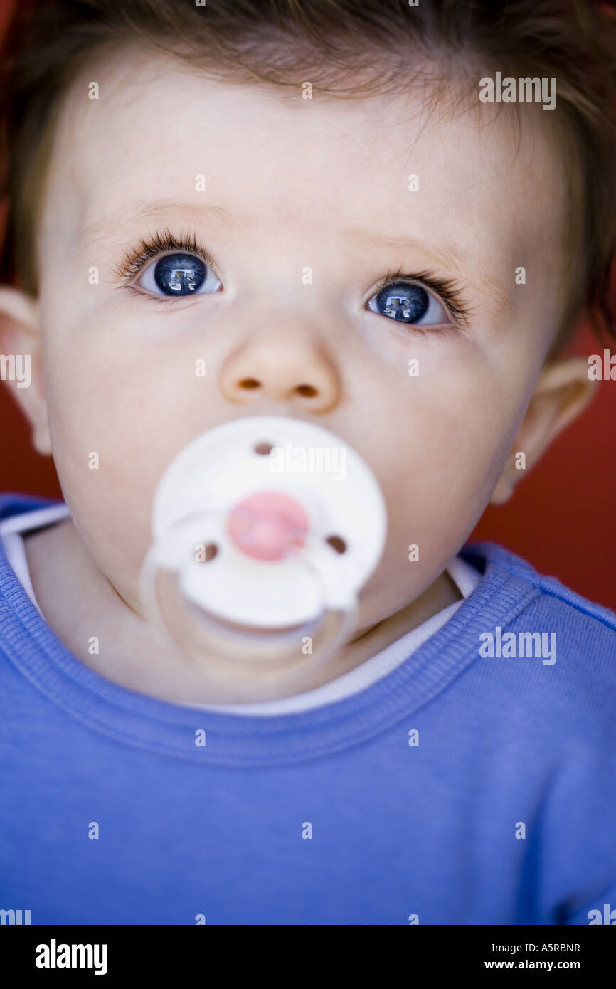 Baby with pacifier and blue eyes Stock Photo - Alamy