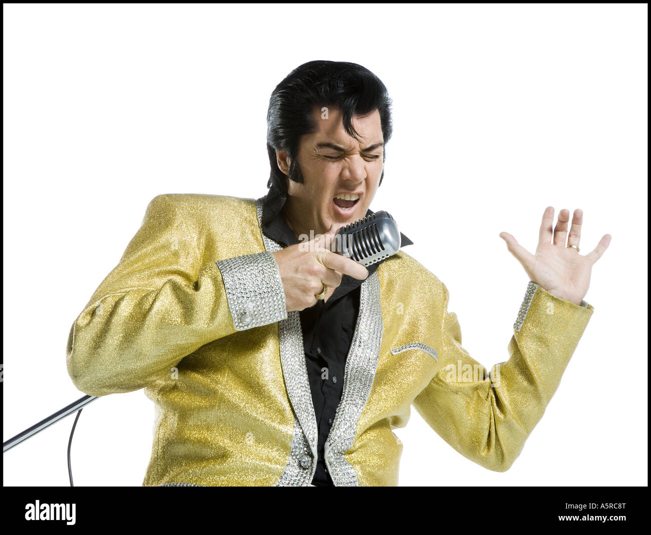 An Elvis impersonator singing into a microphone Stock Photo - Alamy