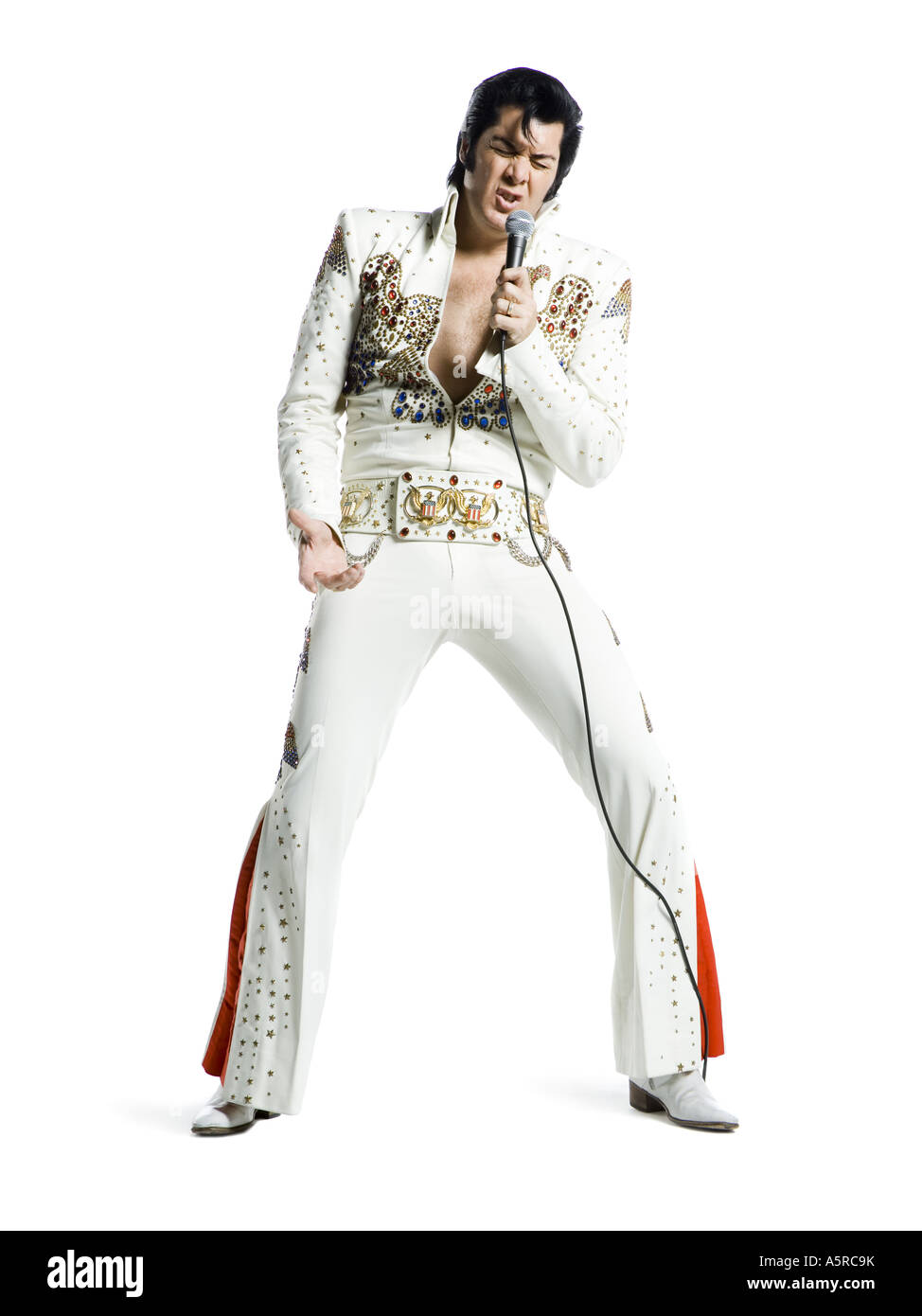 An Elvis impersonator singing into a microphone Stock Photo - Alamy