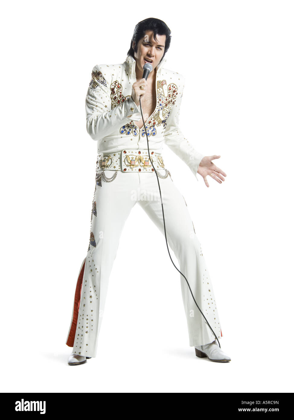 An Elvis impersonator singing into a microphone Stock Photo - Alamy