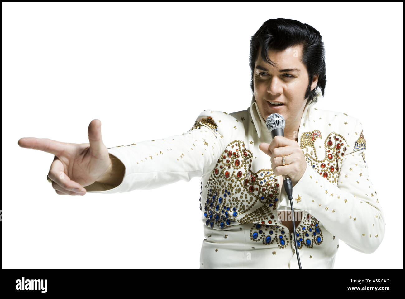 An Elvis impersonator singing into a microphone Stock Photo - Alamy