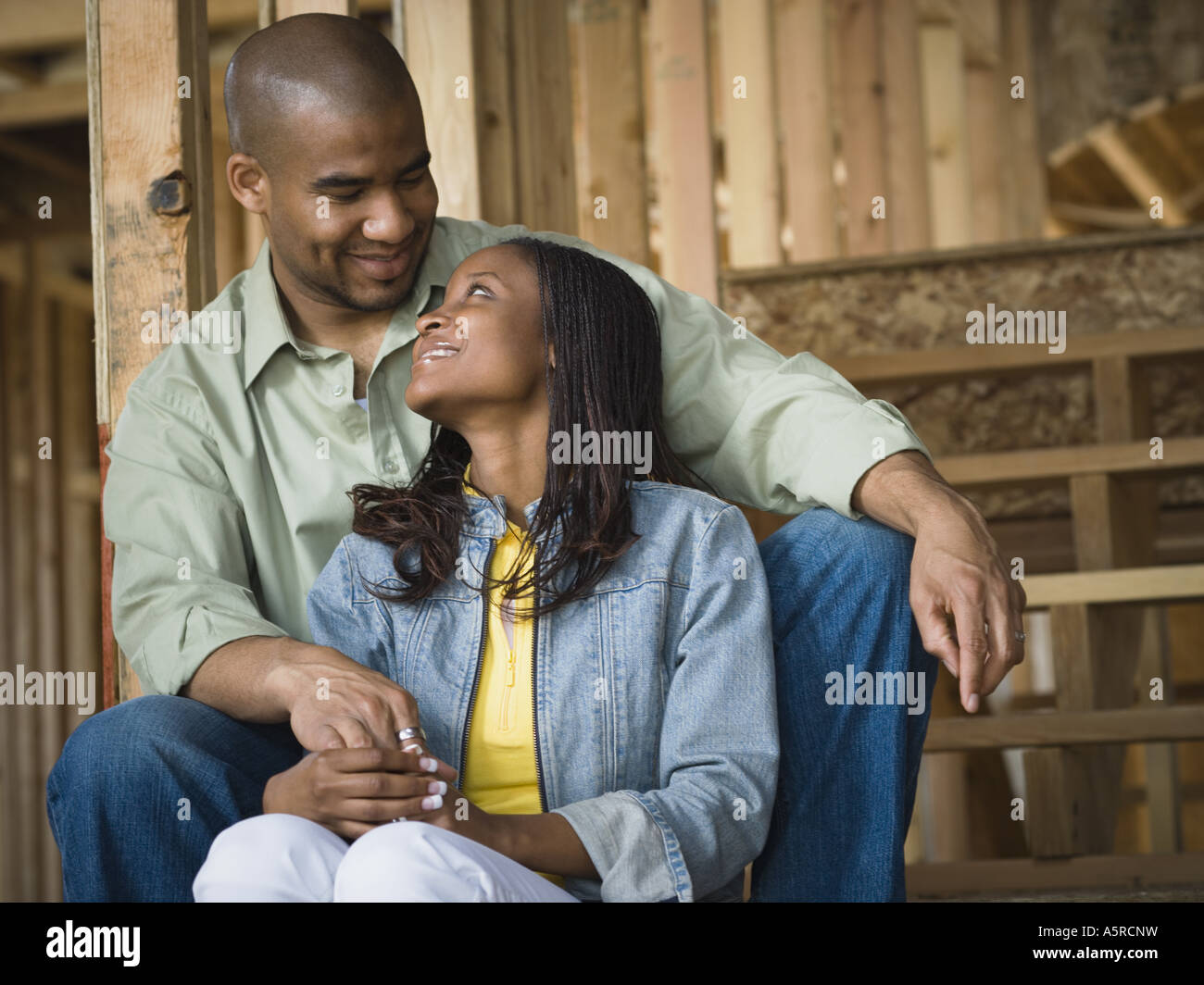 Portrait of a young couple sitting and smiling Stock Photo - Alamy