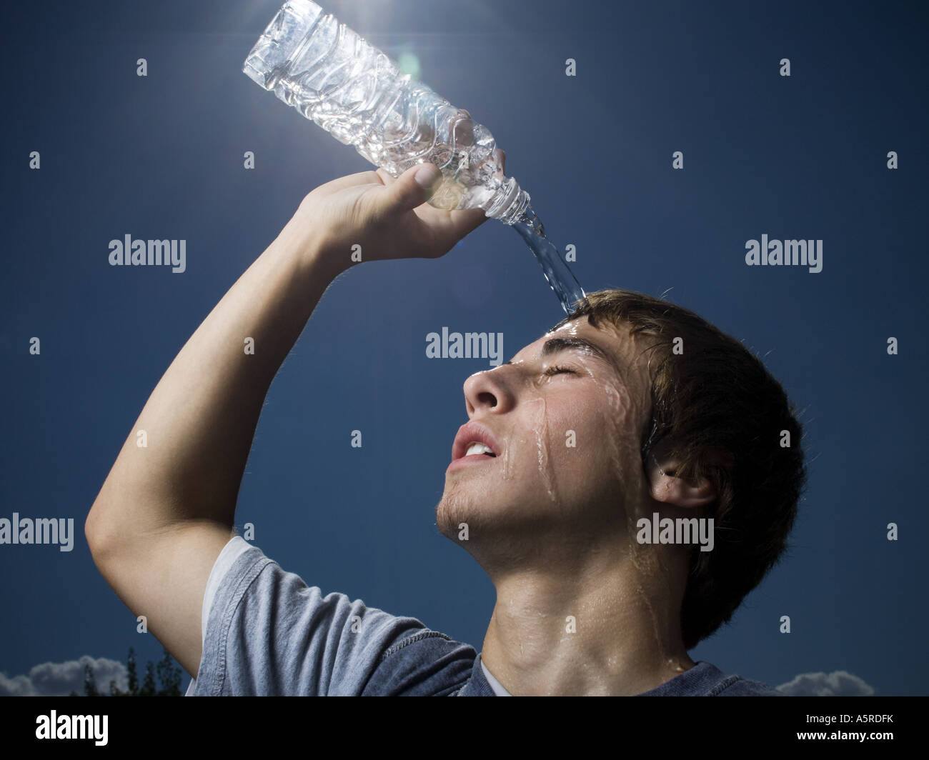Close up of a teenage boy pouring water over his head Stock Photo - Alamy