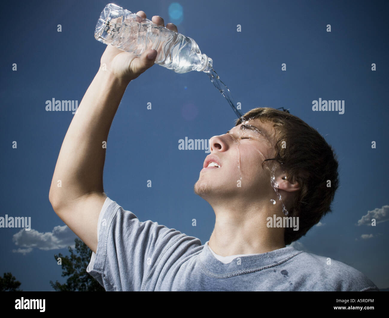 Close up of a teenage boy pouring water over his head Stock Photo - Alamy