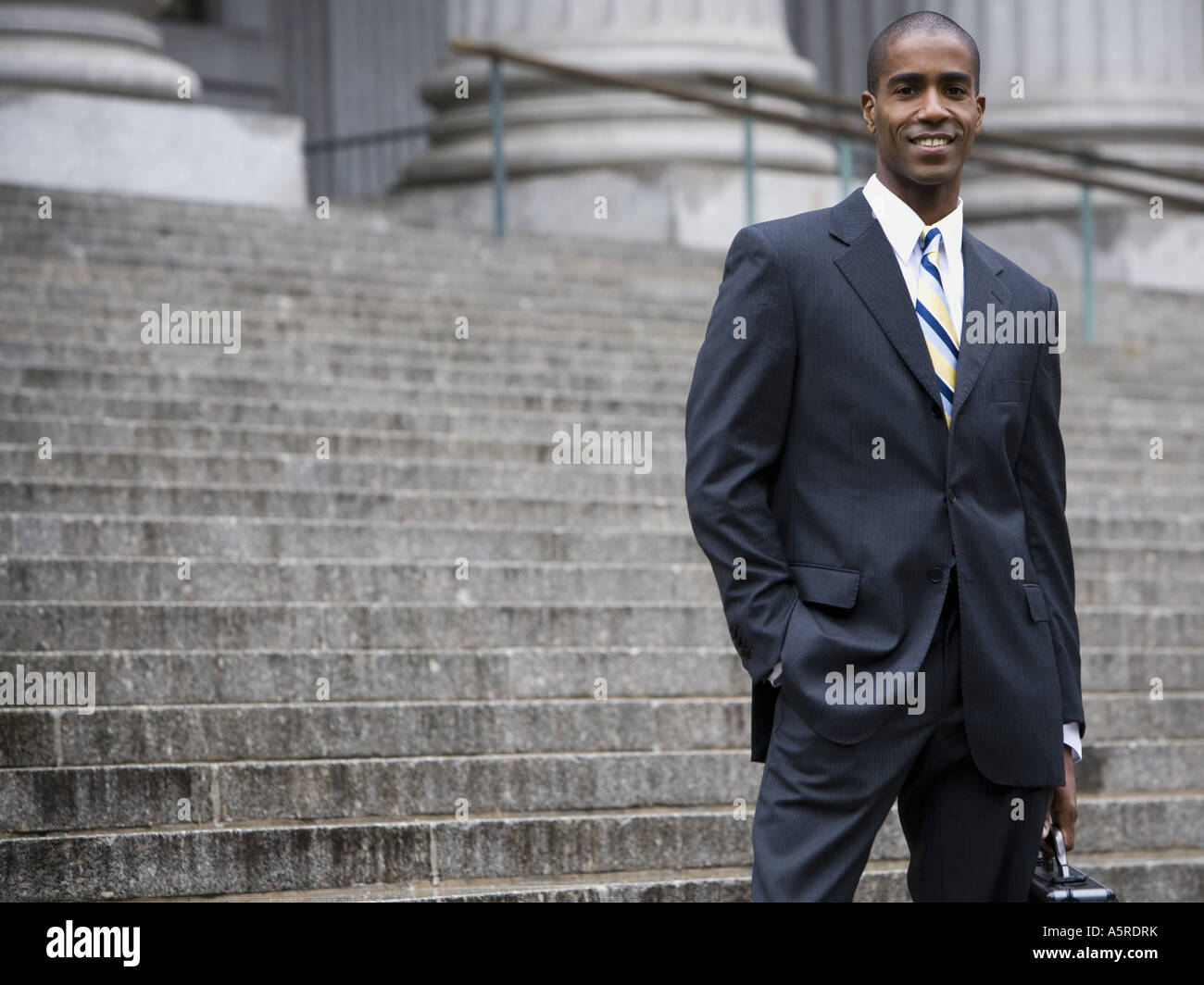 Portrait of a male lawyer standing on the steps of a courthouse and ...