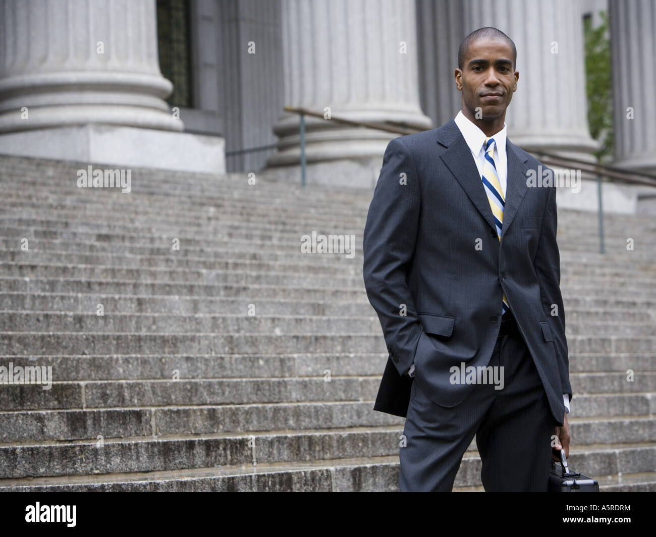 Portrait of a male lawyer standing on the steps of a courthouse and ...
