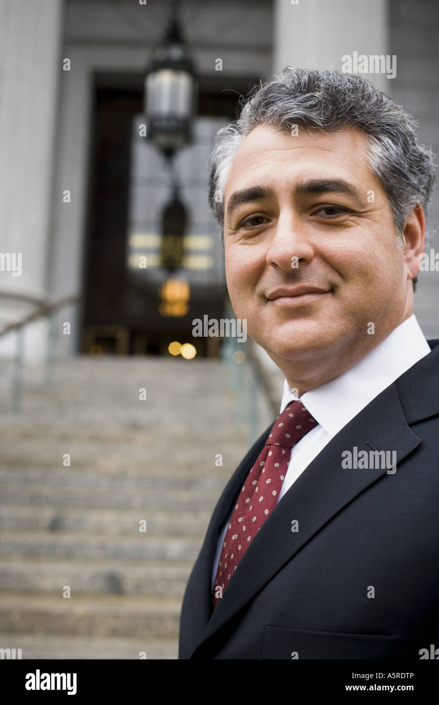 Portrait of a man standing on the steps of a courthouse and smiling ...