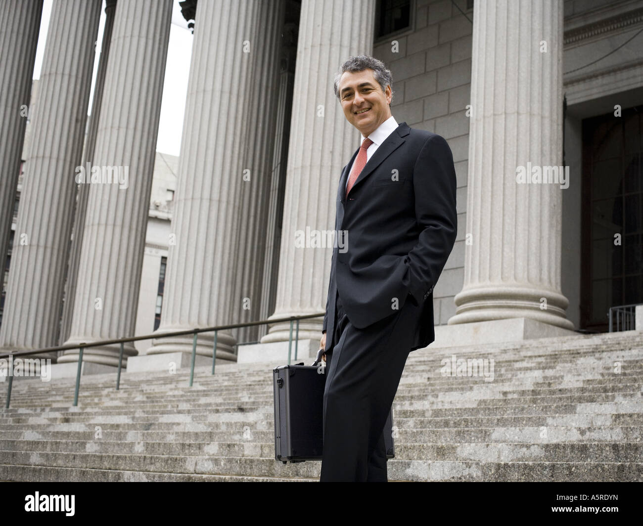 Low angle view of a male lawyer standing on the steps of a courthouse ...