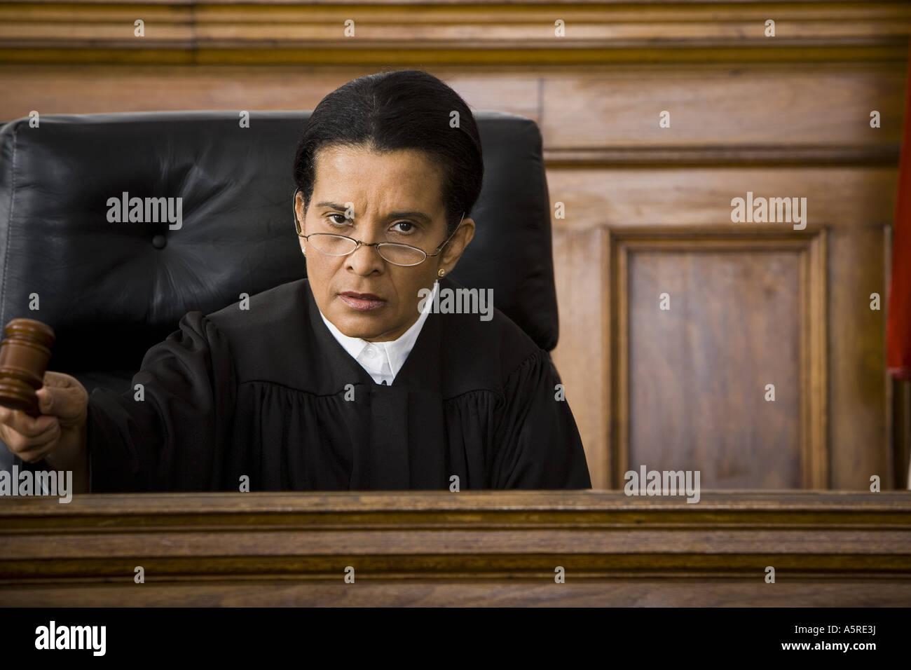 Portrait of a female judge holding a gavel and looking serious Stock ...