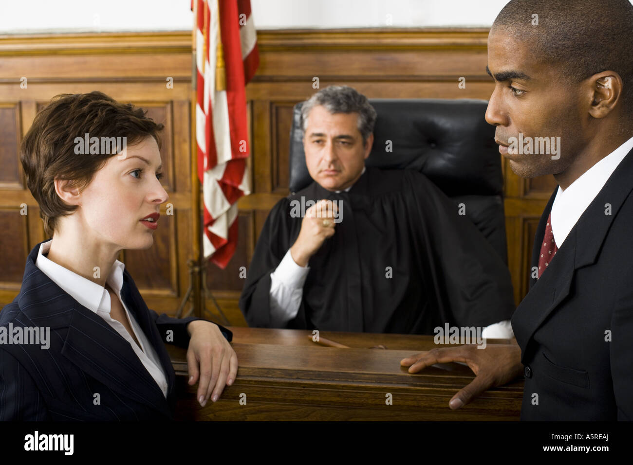 Two lawyers standing face to face in front of a male judge in a ...