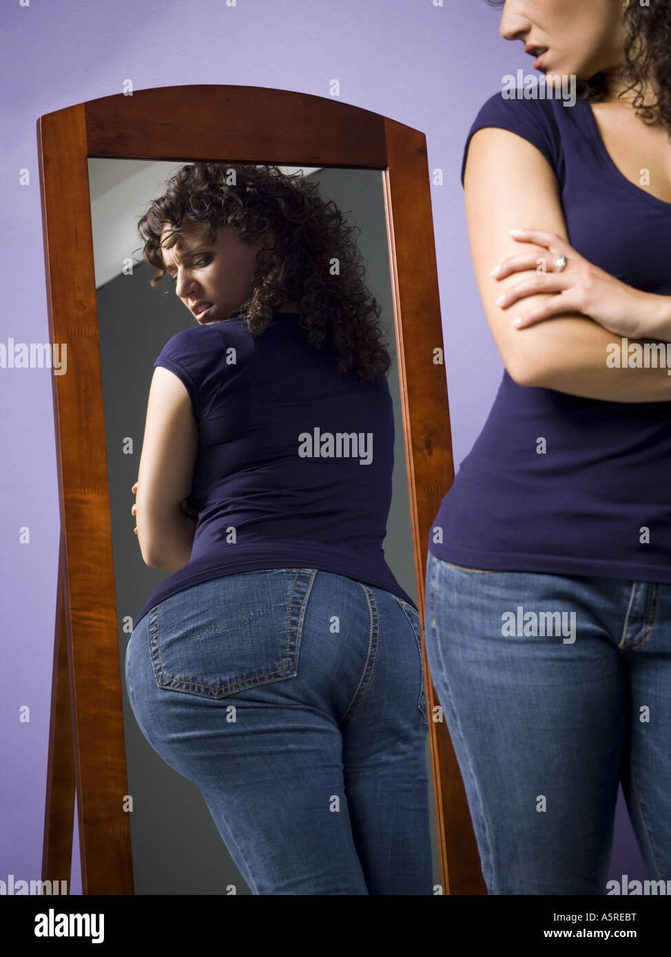 Young woman looking at her buttocks in the mirror Stock Photo - Alamy