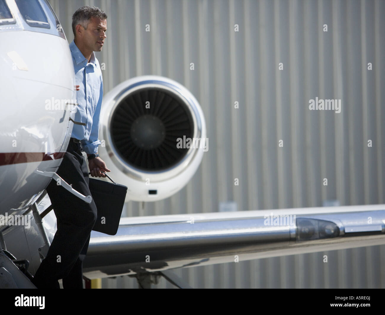 Profile of a businessman exiting an airplane Stock Photo - Alamy